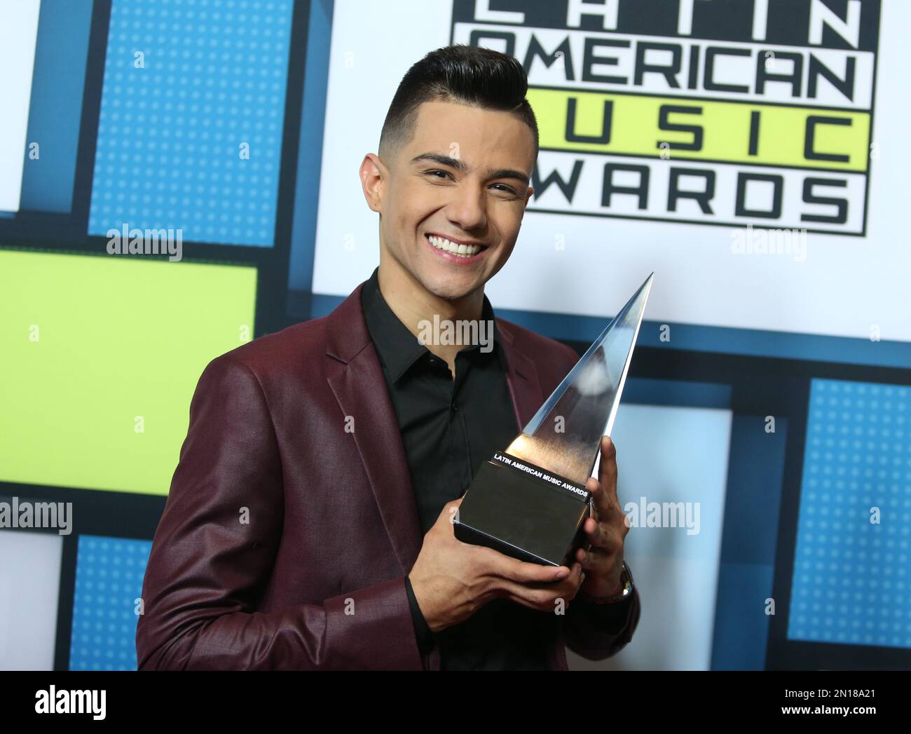 Luis Coronel poses backstage with the award for favorite male artist ...