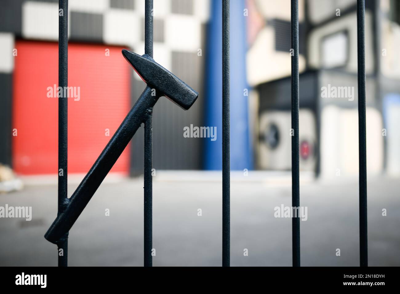 hammer element on metal fence painted in black in front of a factory in ...