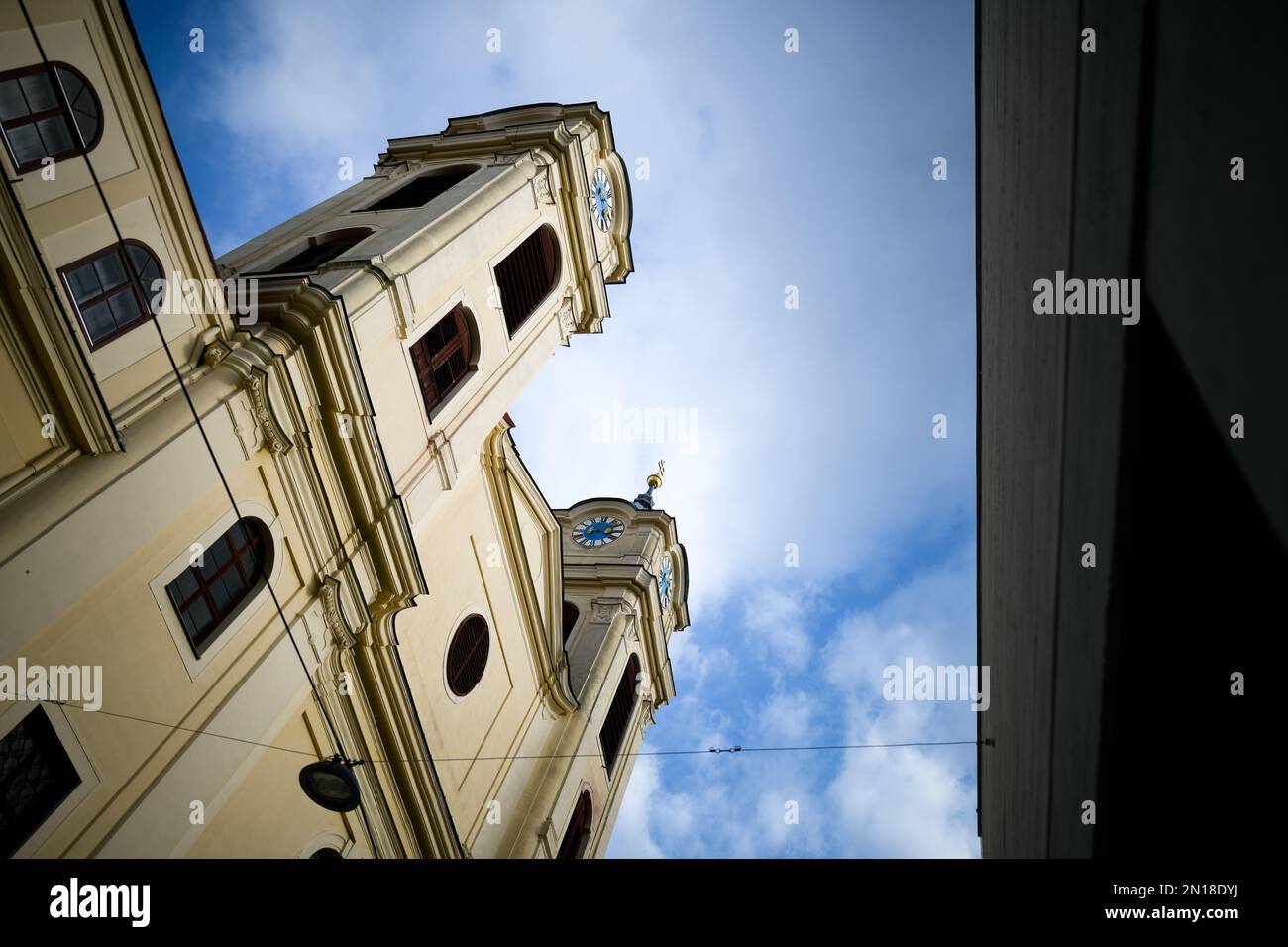 simple old yellow catholic church with two identical clock towers in ...