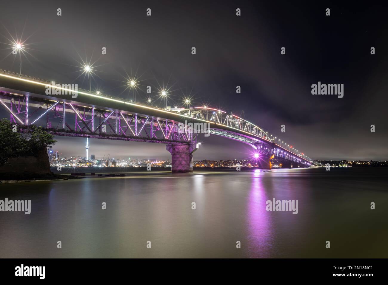 Auckland Harbour Bridge glowing in purple. Auckland, New Zealand Stock ...