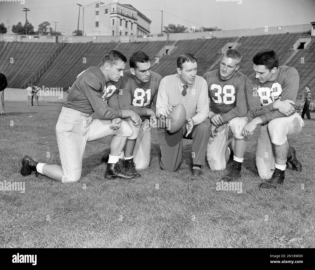 Notre Dame coach Frank Leahy goes into a final huddle with four of his ...