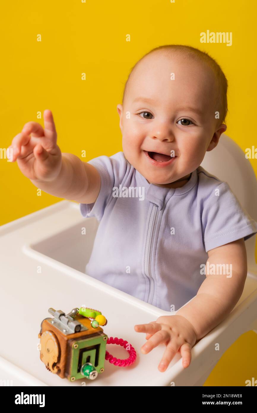 a cute kid is sitting in a child's chair playing with an educational ...