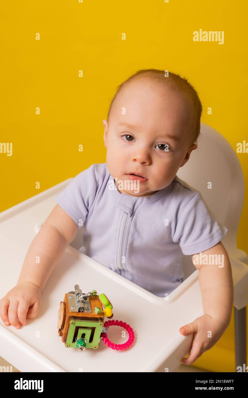 a cute kid is sitting in a child's chair playing with an educational ...