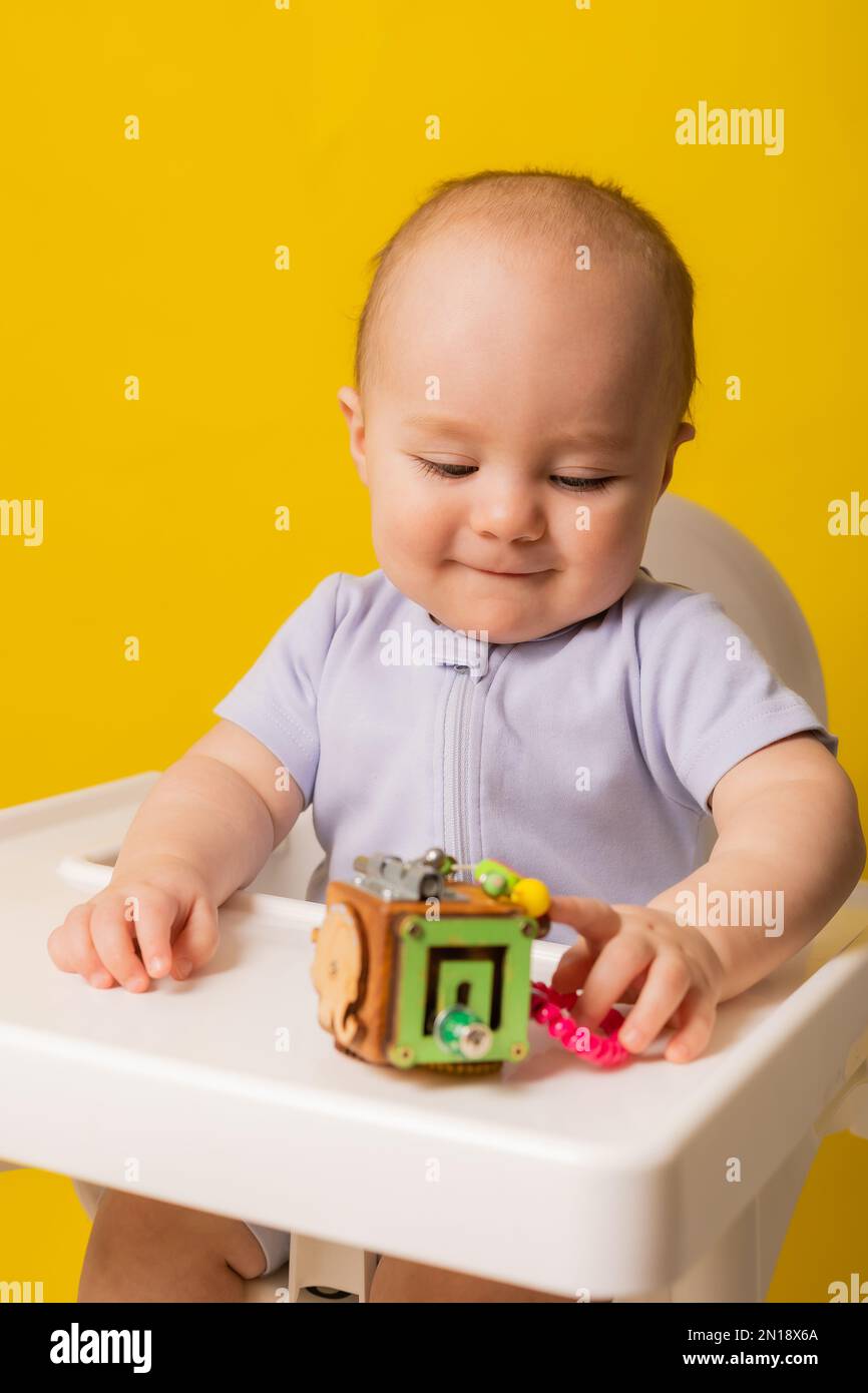 a cute kid is sitting in a child's chair playing with an educational ...