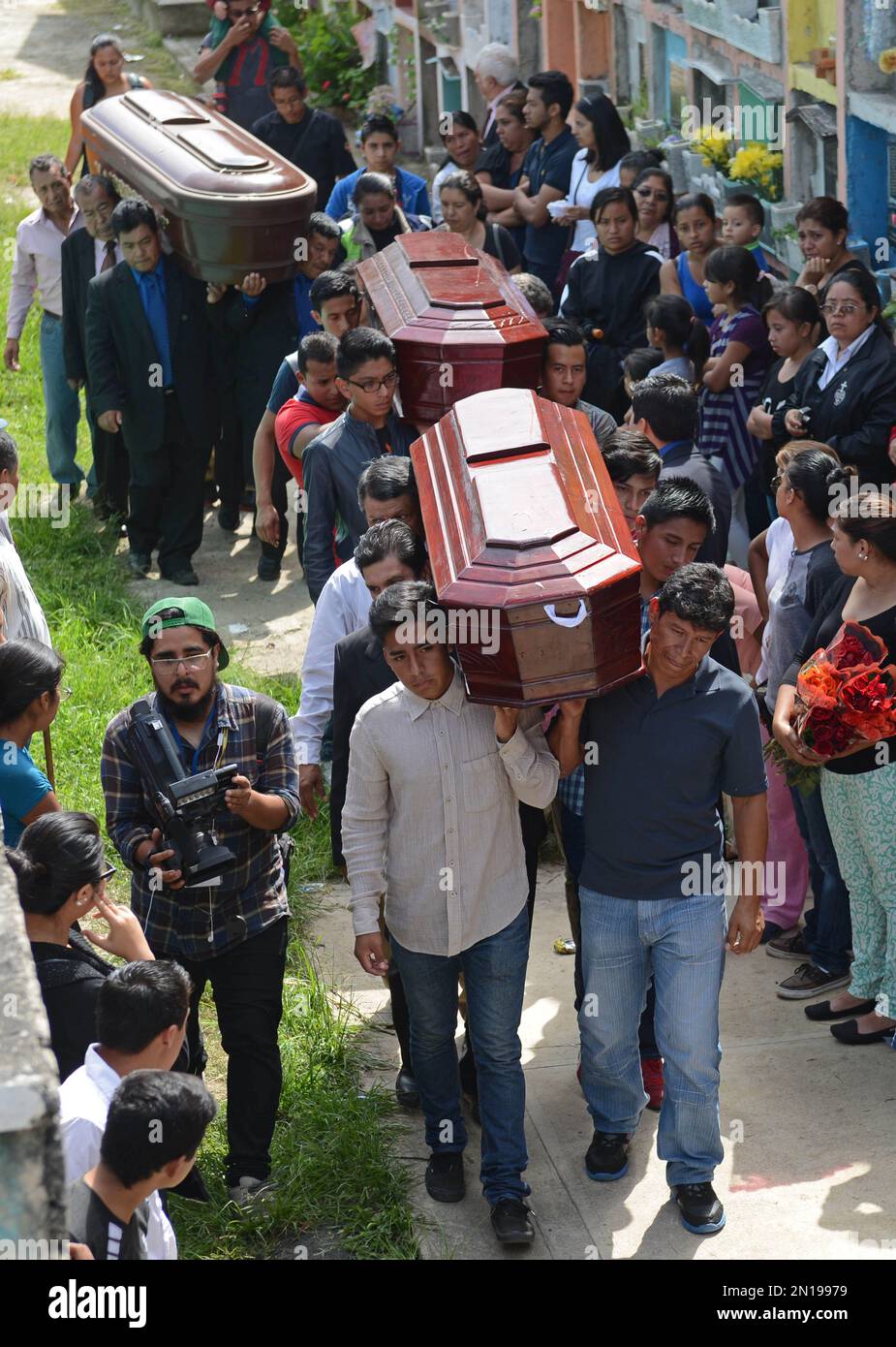 People carry the coffins of four members of the Valenzuela family who ...