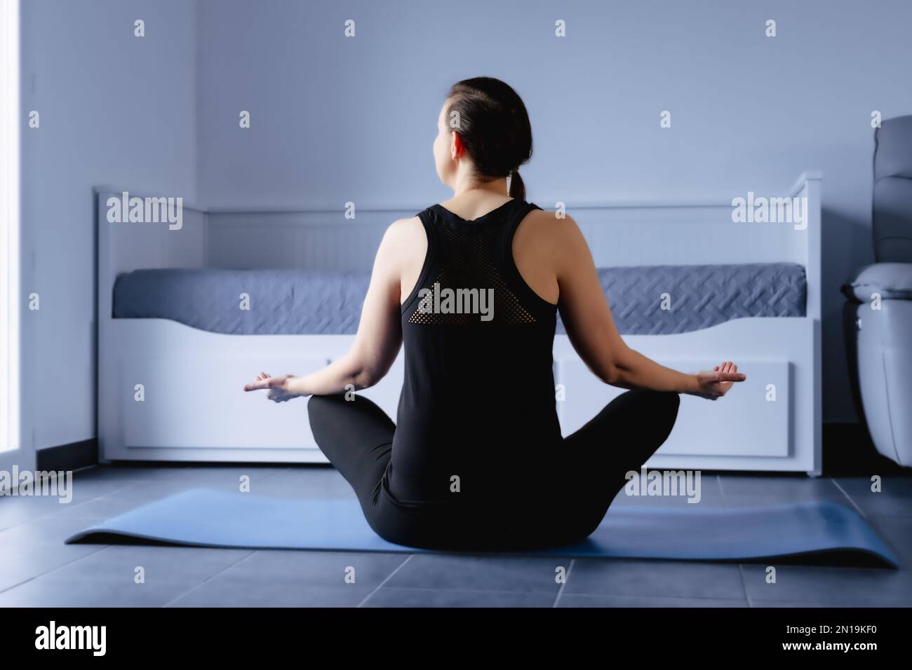 Woman practicing yoga indoor for training, stretching and relaxation ...