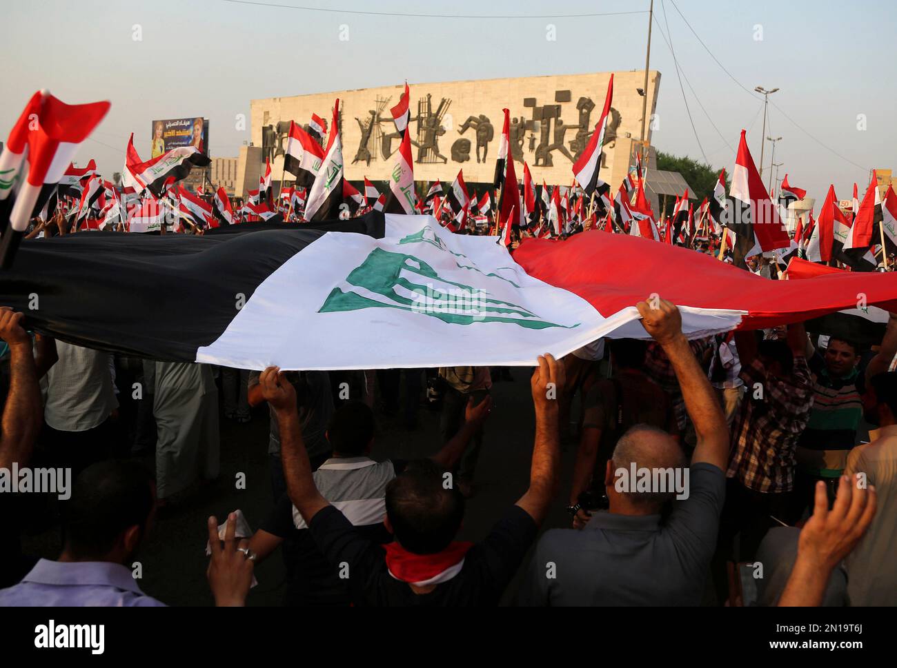 Iraqi protesters chant slogans as they wave national flags during a ...
