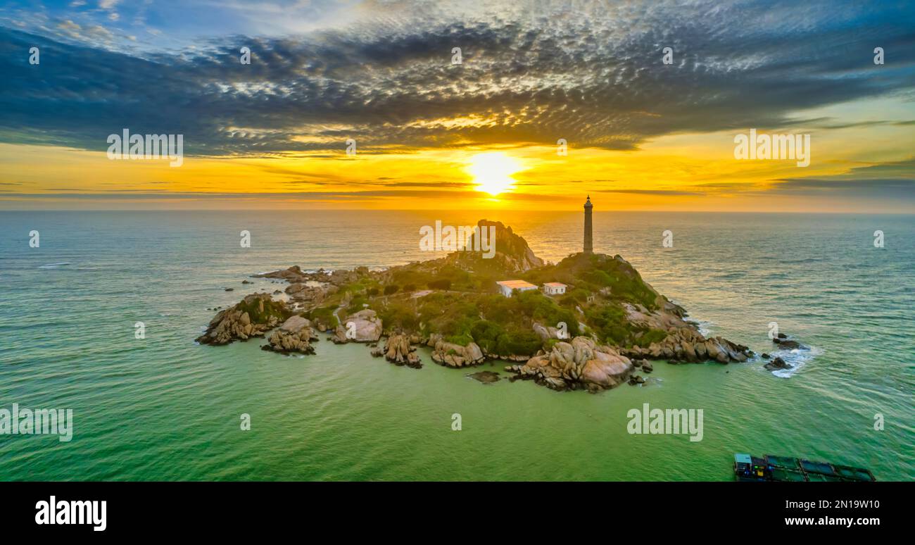 Landscape of small island with ancient lighthouse at sunrise sky is ...