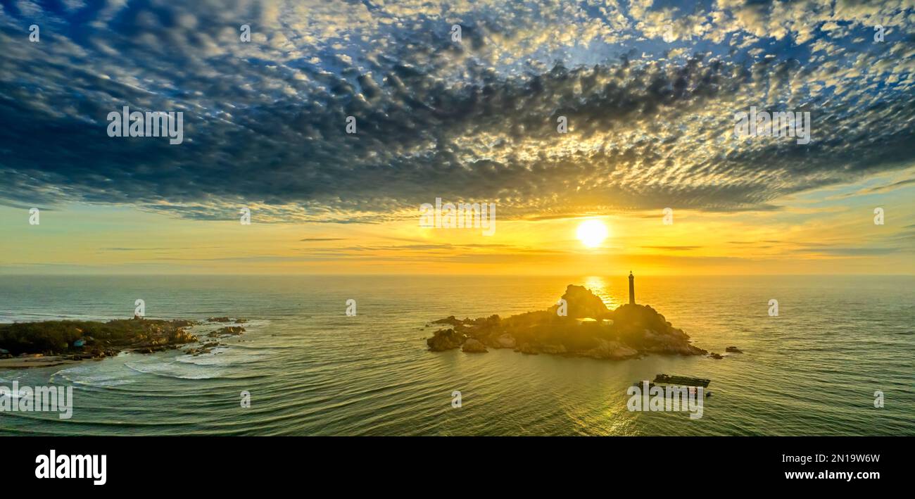 Landscape of small island with ancient lighthouse at sunrise sky is ...