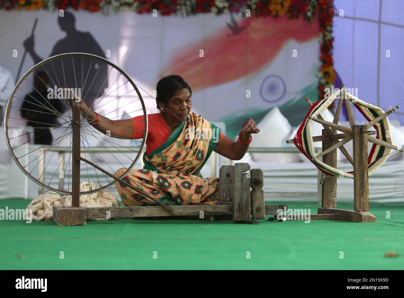 An Indian women makes thread for weaving to mark the birth anniversary ...