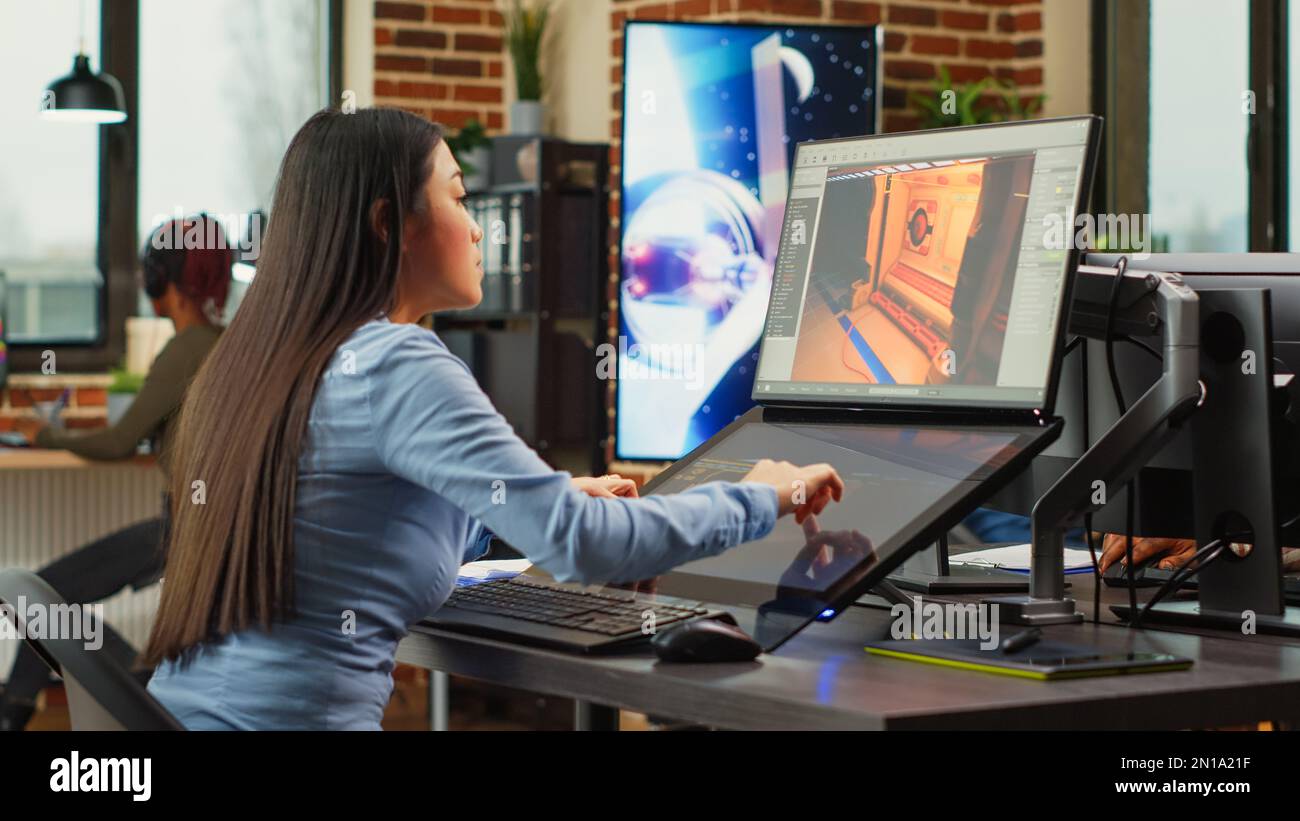 Asian game developer working in production department to create ...