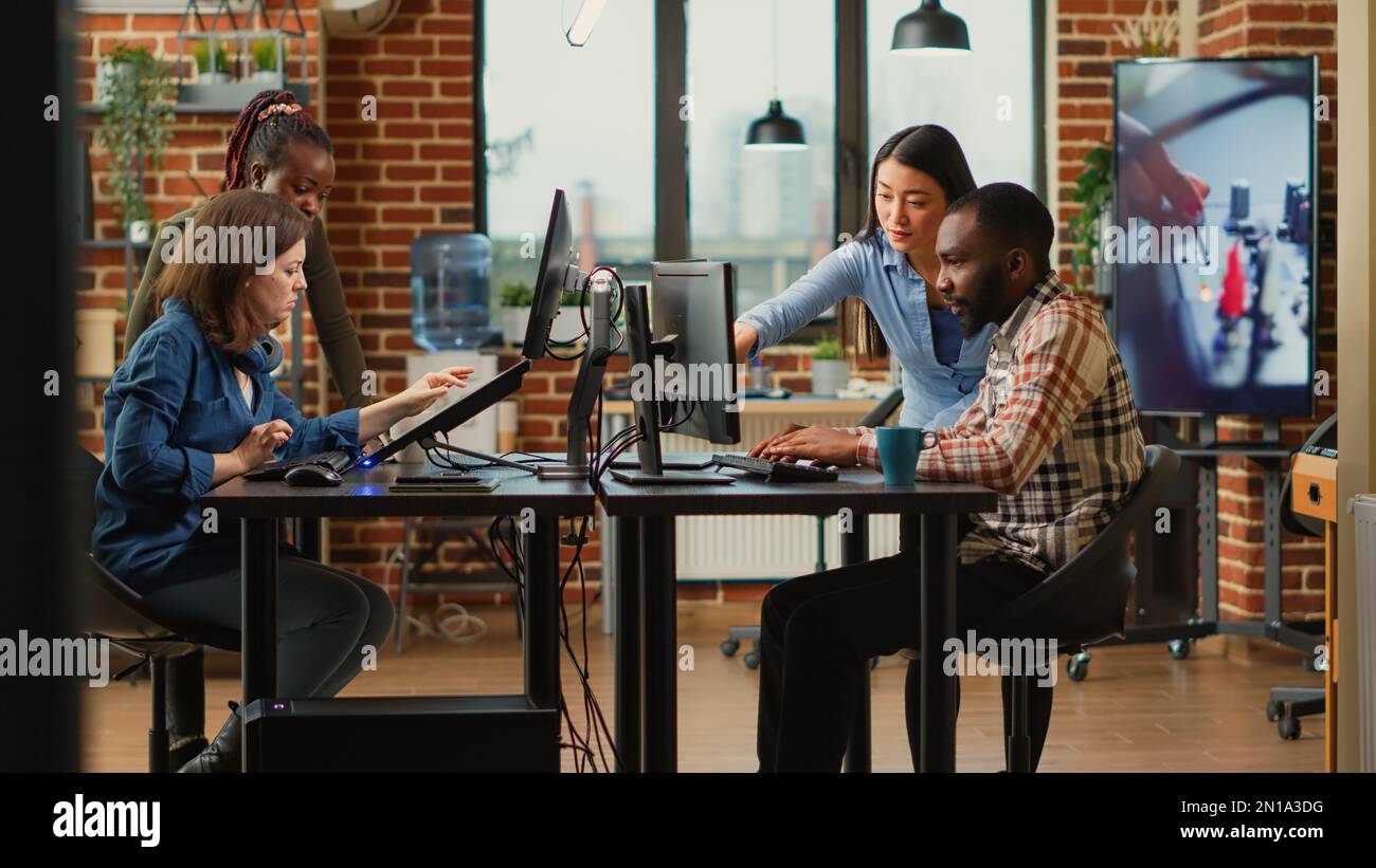 Diverse engineers working on turbine component with modern electronics ...