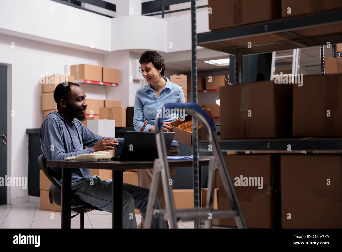 Storehouse employees having fun at job while preparing clients packages ...