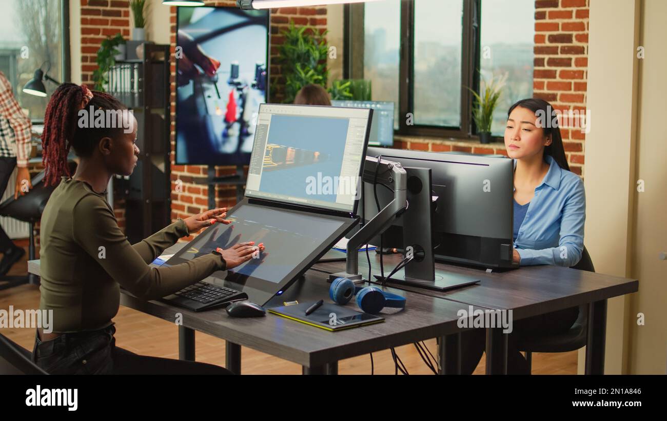 African american worker using game developing software on computer and ...