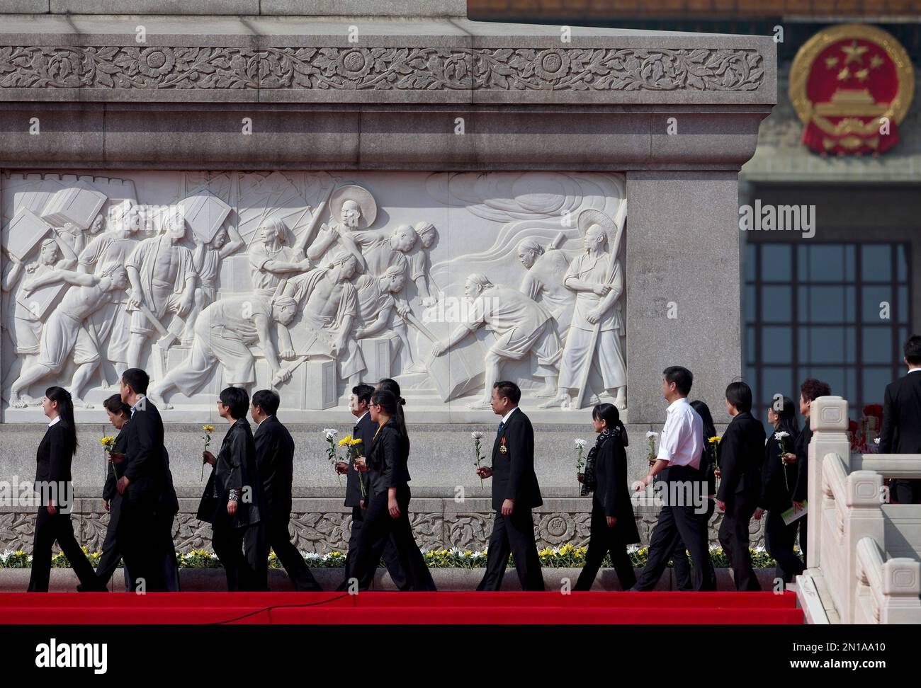 Chinese officials wait in queue to place flowers at the People's Heroes ...