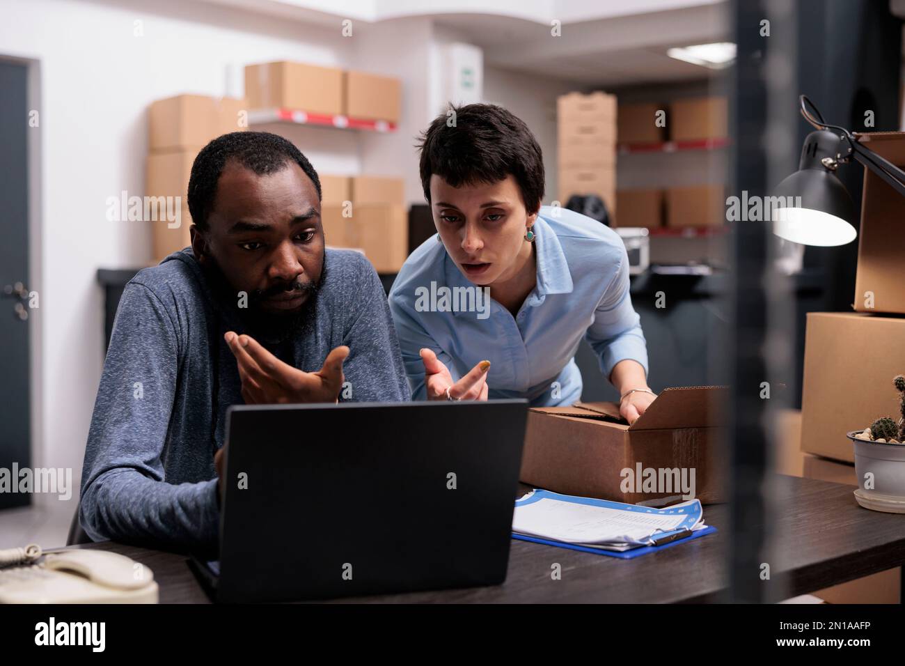 Diverse team looking at cargo stock on laptop computer discussing ...