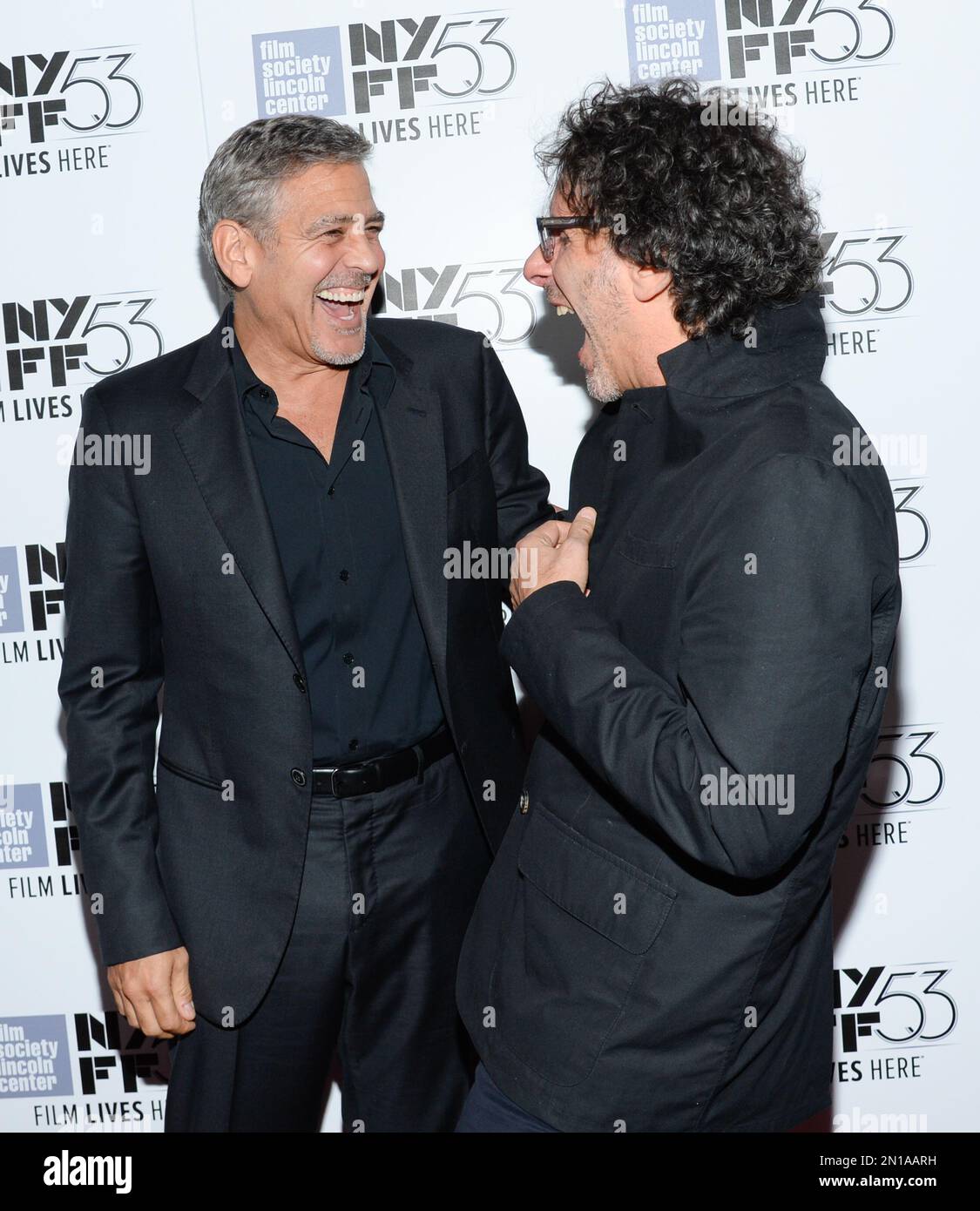 Actor George Clooney, left, shares a laugh with director Joel Coen on the red carpet before a ...