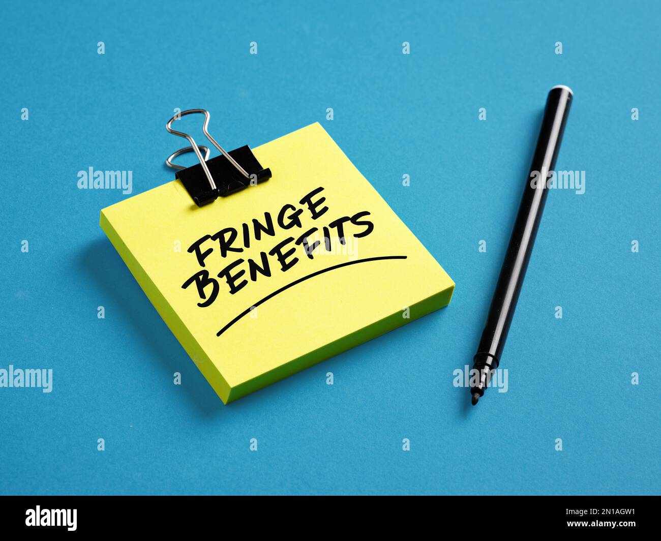 The message fringe benefits on yellow sticky note paper with a black ...