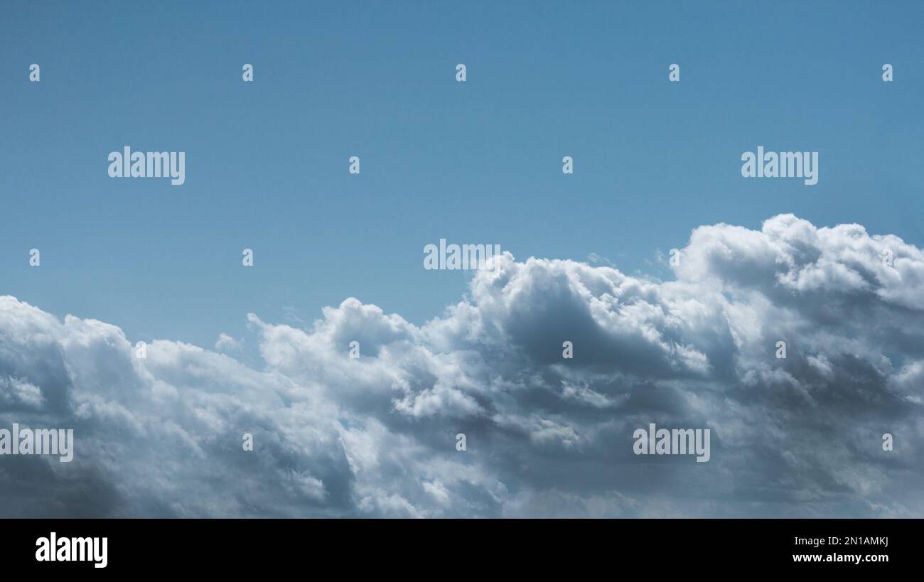 Light blue sky with cumulus clouds of gray color Stock Photo - Alamy