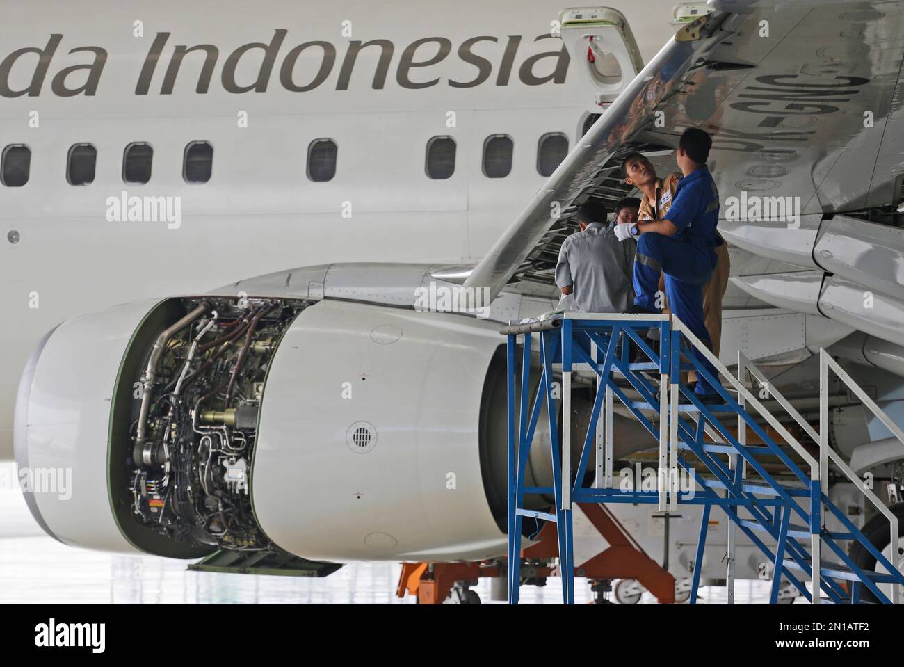 Technicians perform maintenance work on a jetliner at GMF AeroAsia's ...