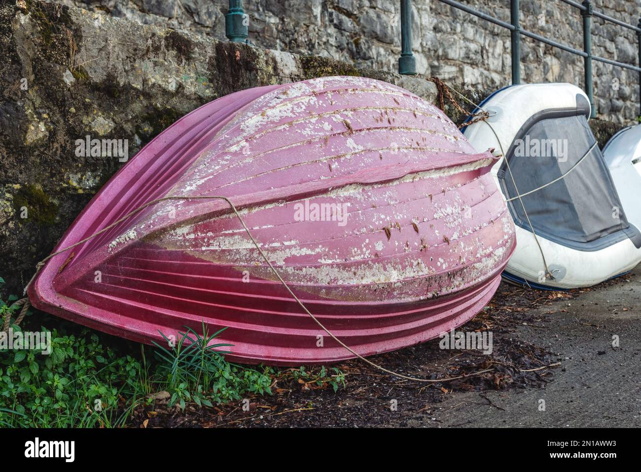Small dinghy boats on turned over on shoreline dock, selective focus ...
