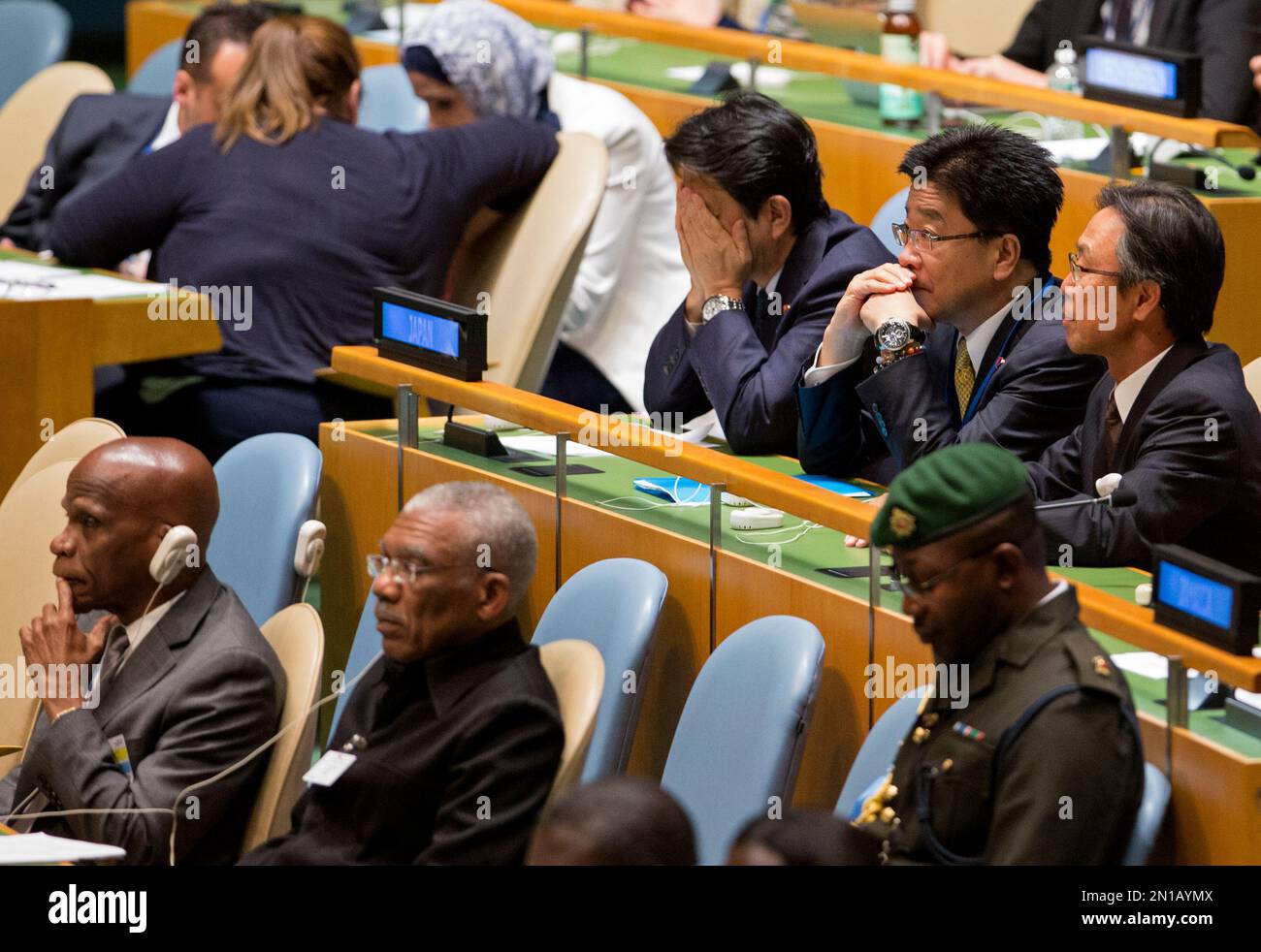 Prime Minister Shinzo Abe, of Japan, places his hands on his face just ...