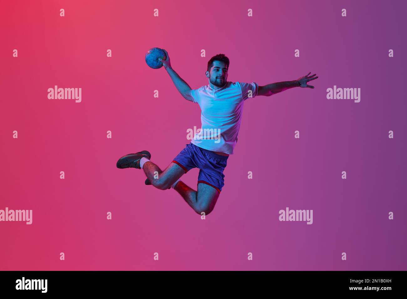 Throwing ball in jump. Young man, professional handball player training ...