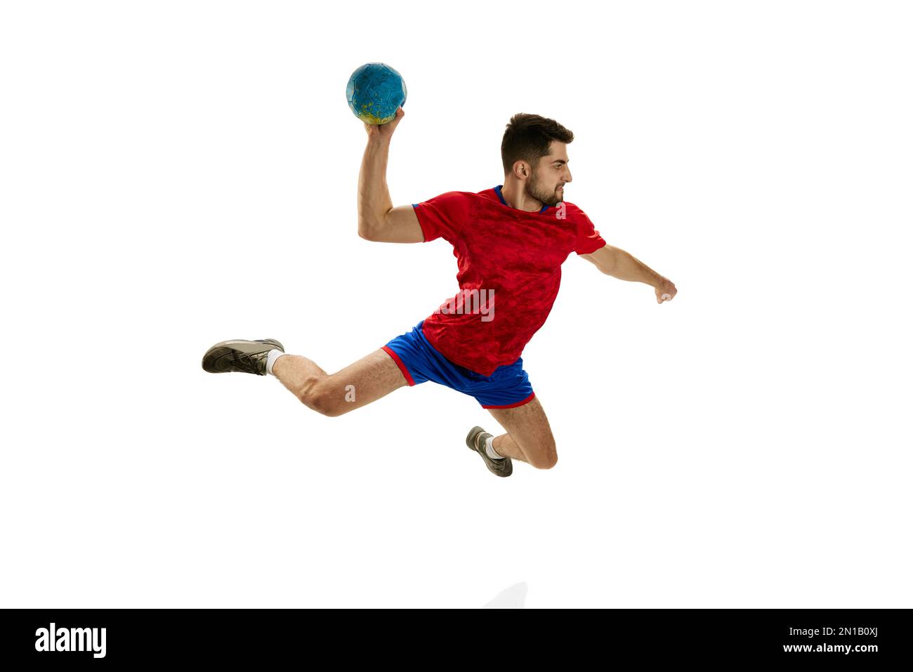 In a jump. Dynamics. Young man, professional handball player in red ...