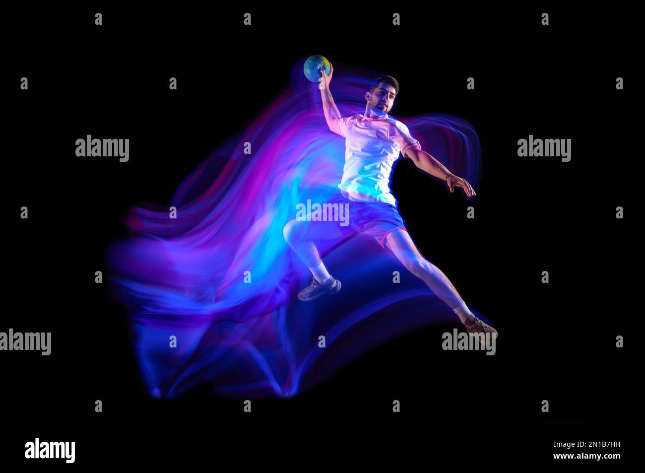 Throwing ball in a jump. Young man, professional handball player in ...