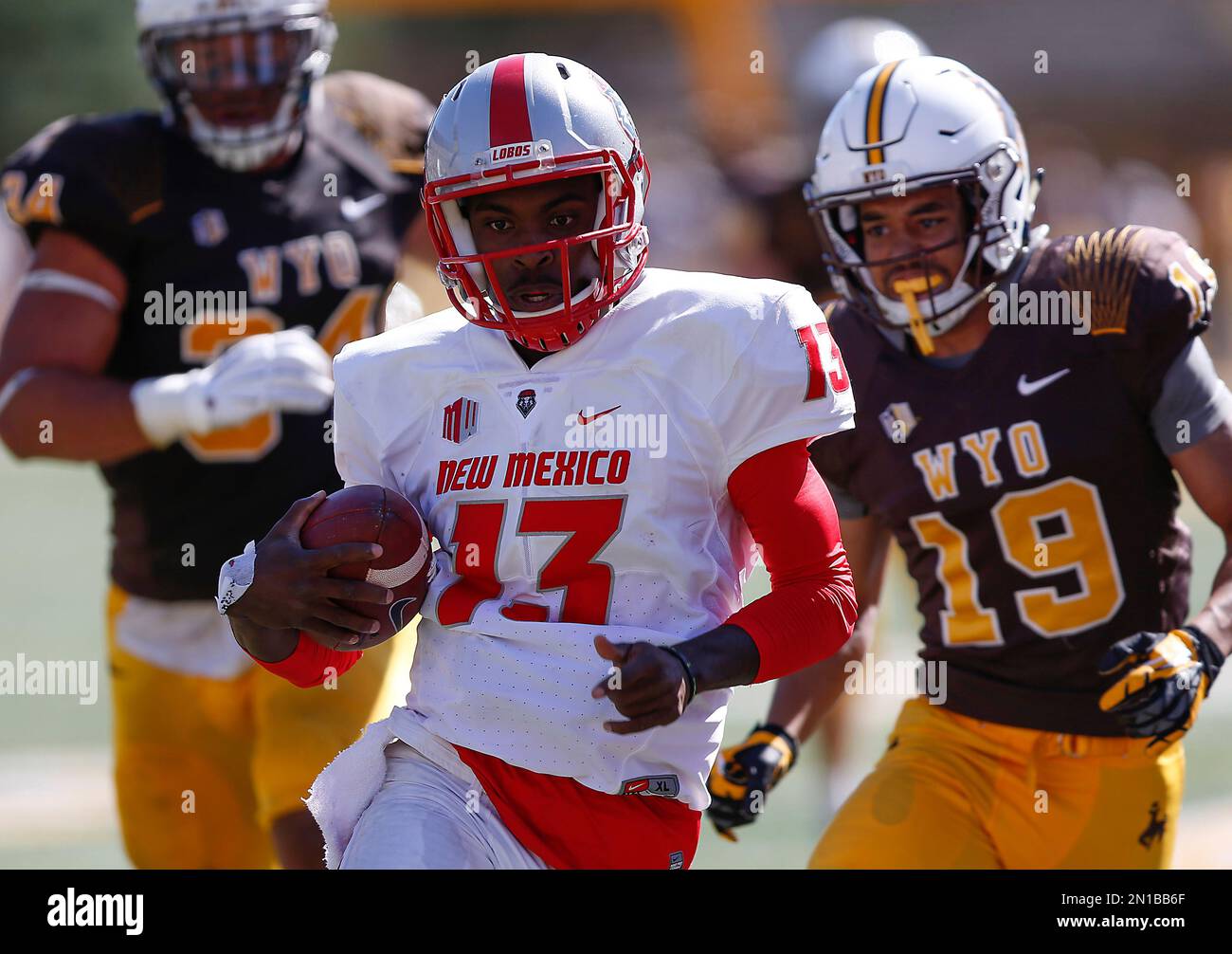 New Mexico's Lamar Jordan(13) runs past Wyoming's Anthony Makransky(19 ...