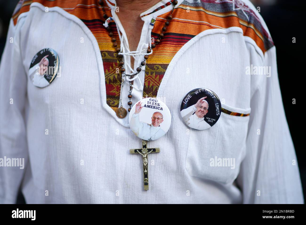 A supporter wears Pope Francis buttons at the barricades around the ...