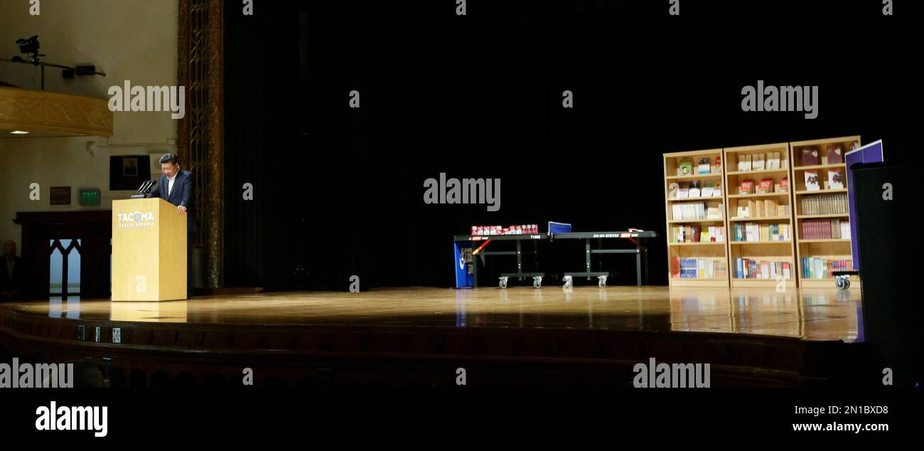 Chinese President Xi Jinping speaks as shelves of books and a ping pong ...