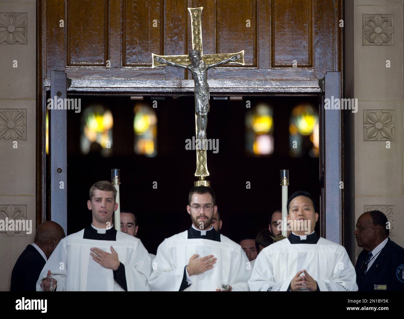 Priests arrive with a crucifix for an outdoor mass at the Basilica of ...