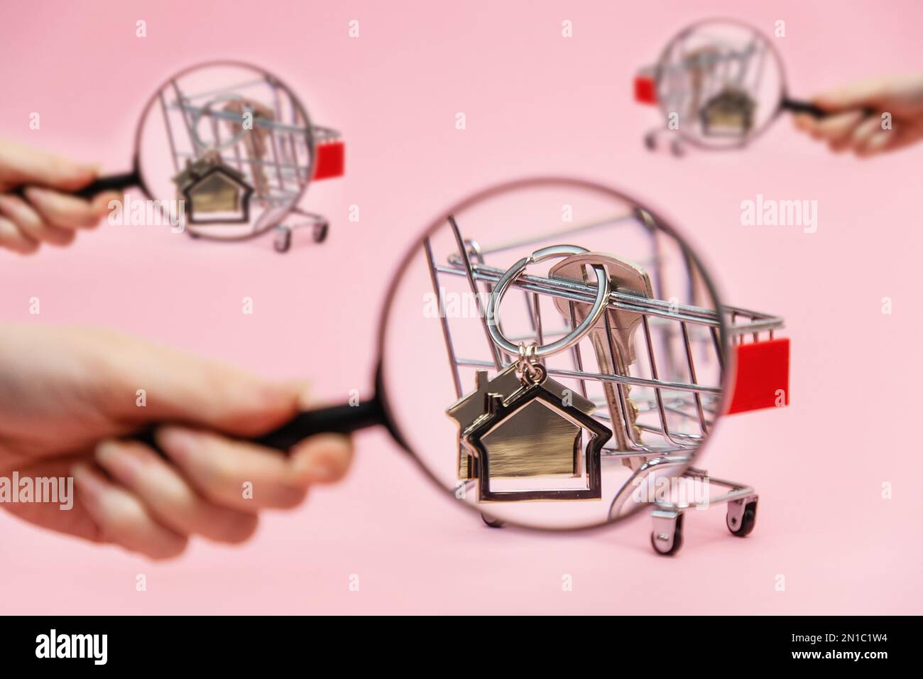 Females hands holding a magnifier glass and showing zoomed key and ...