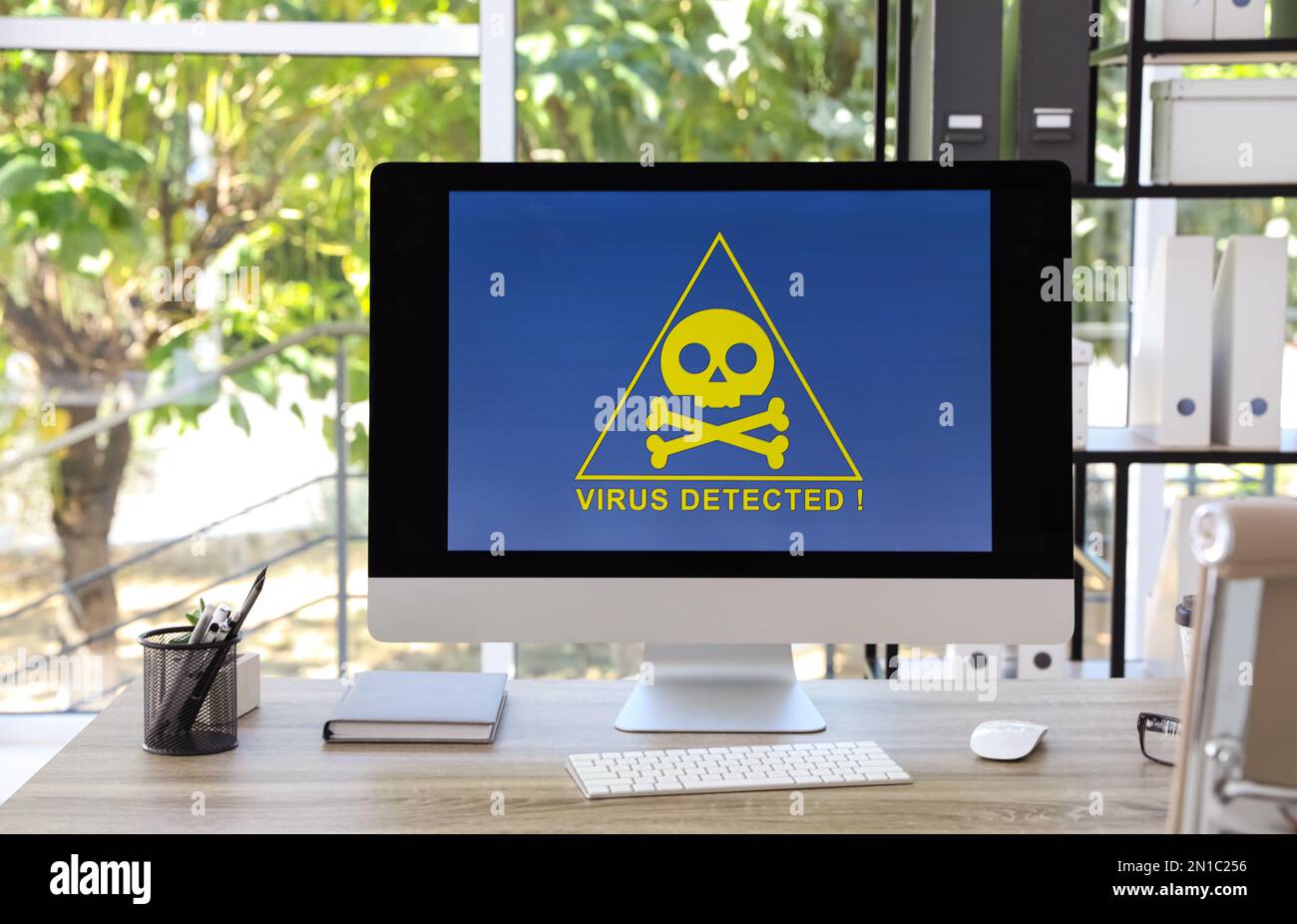 Computer with warning about virus attack on screen in office Stock ...