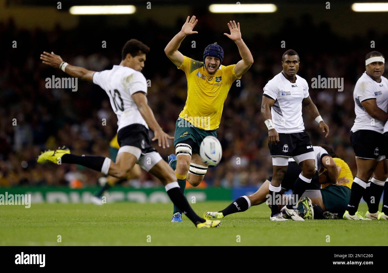 Australia's Dean Mumm charges towards a kick from Fiji's Ben Volavola ...