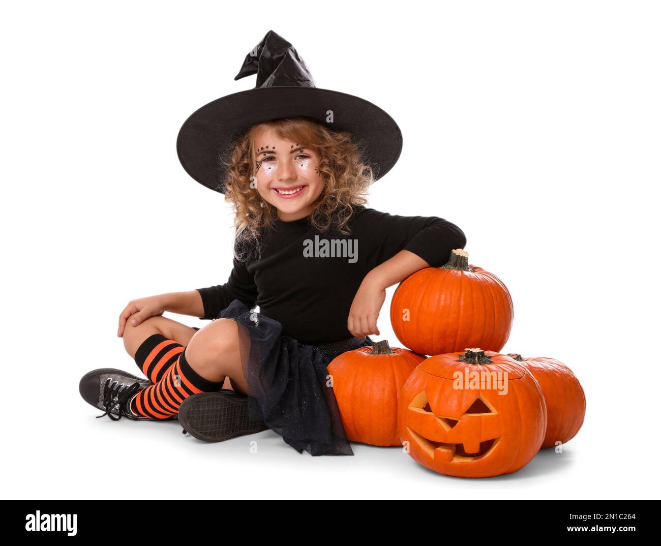 Cute little girl wearing Halloween costume and pumpkins on white ...