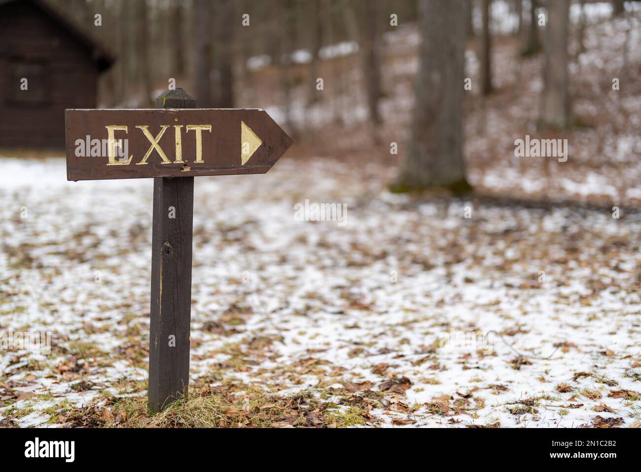 Winter scene with a rustic wooden exit sign with arrow pointing right ...