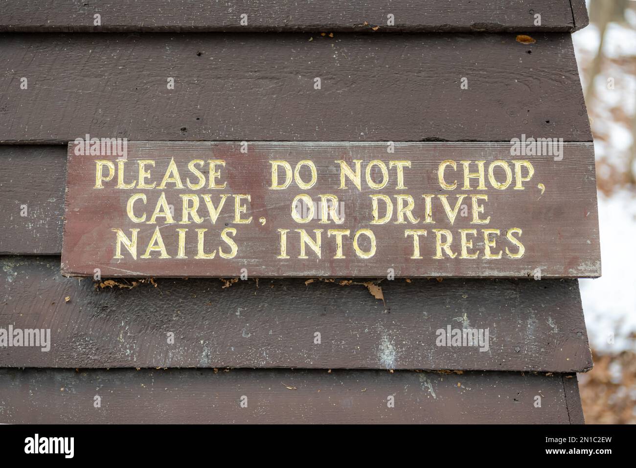 Weathered wood sign on building, please do not chop, carve, or drive ...