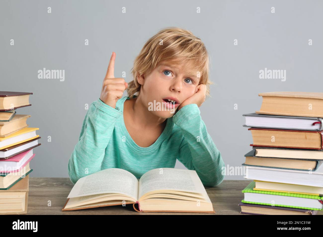 Little boy doing homework at table on grey background Stock Photo - Alamy