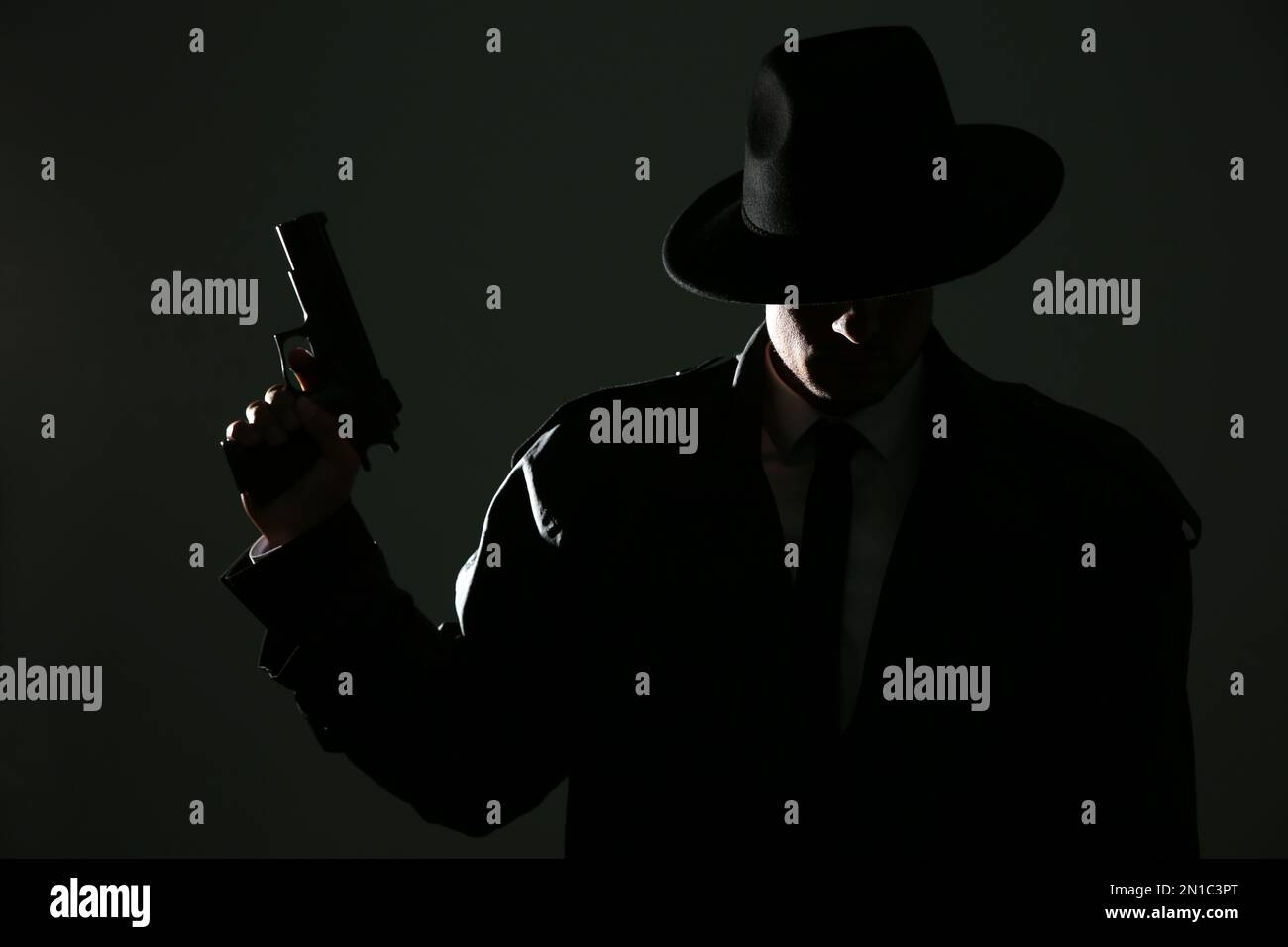 Old fashioned detective with gun on dark background Stock Photo - Alamy