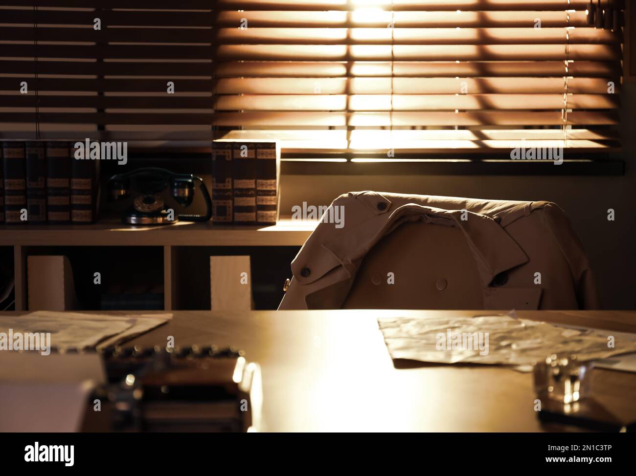 Grey coat on chair near wooden table in detective office Stock Photo ...