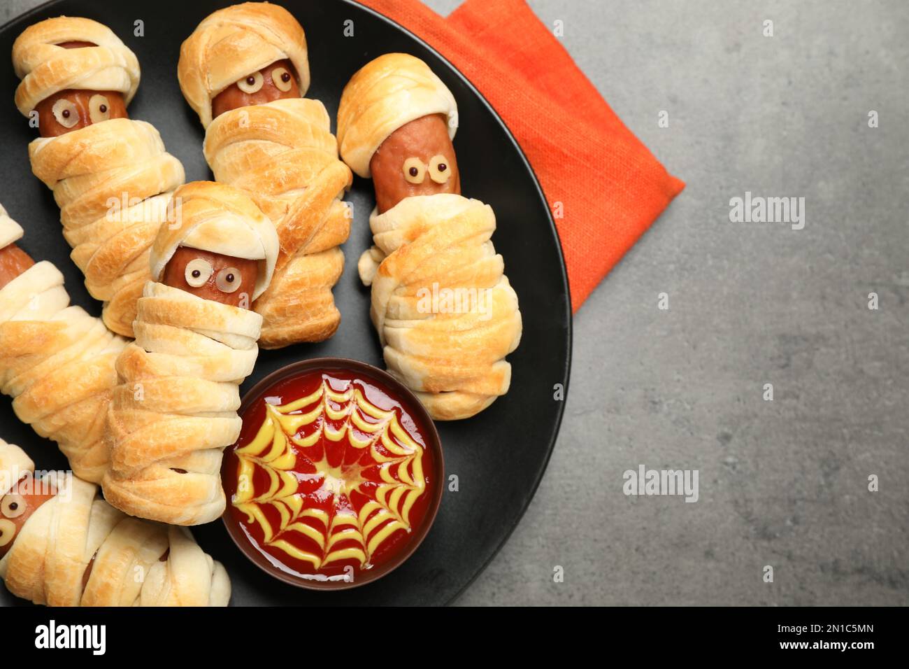 Spooky sausage mummies for Halloween party served on grey table, top ...