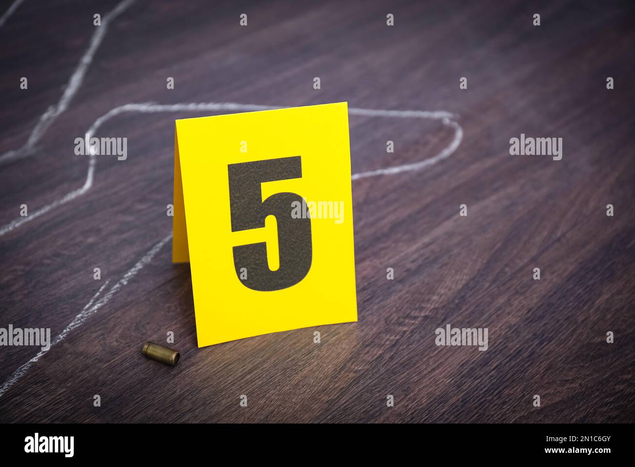 Bullet shell and evidence marker near chalk outline on wooden floor ...