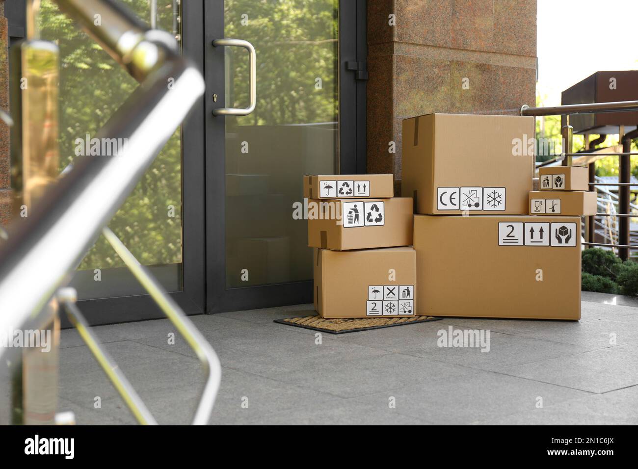 Cardboard boxes with different packaging symbols on door mat near ...