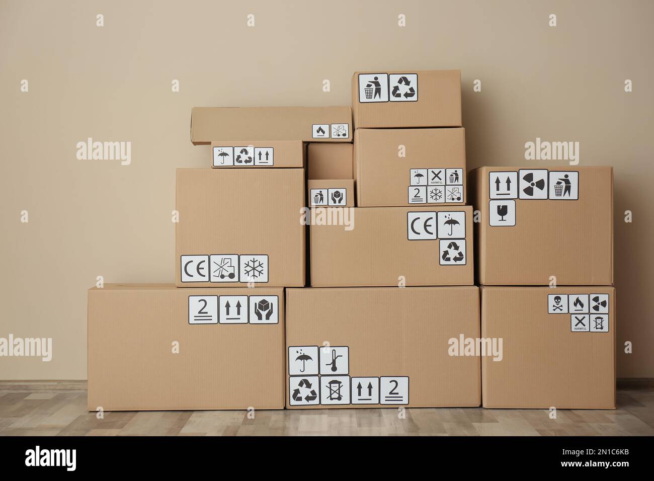 Cardboard boxes with different packaging symbols on floor near beige ...