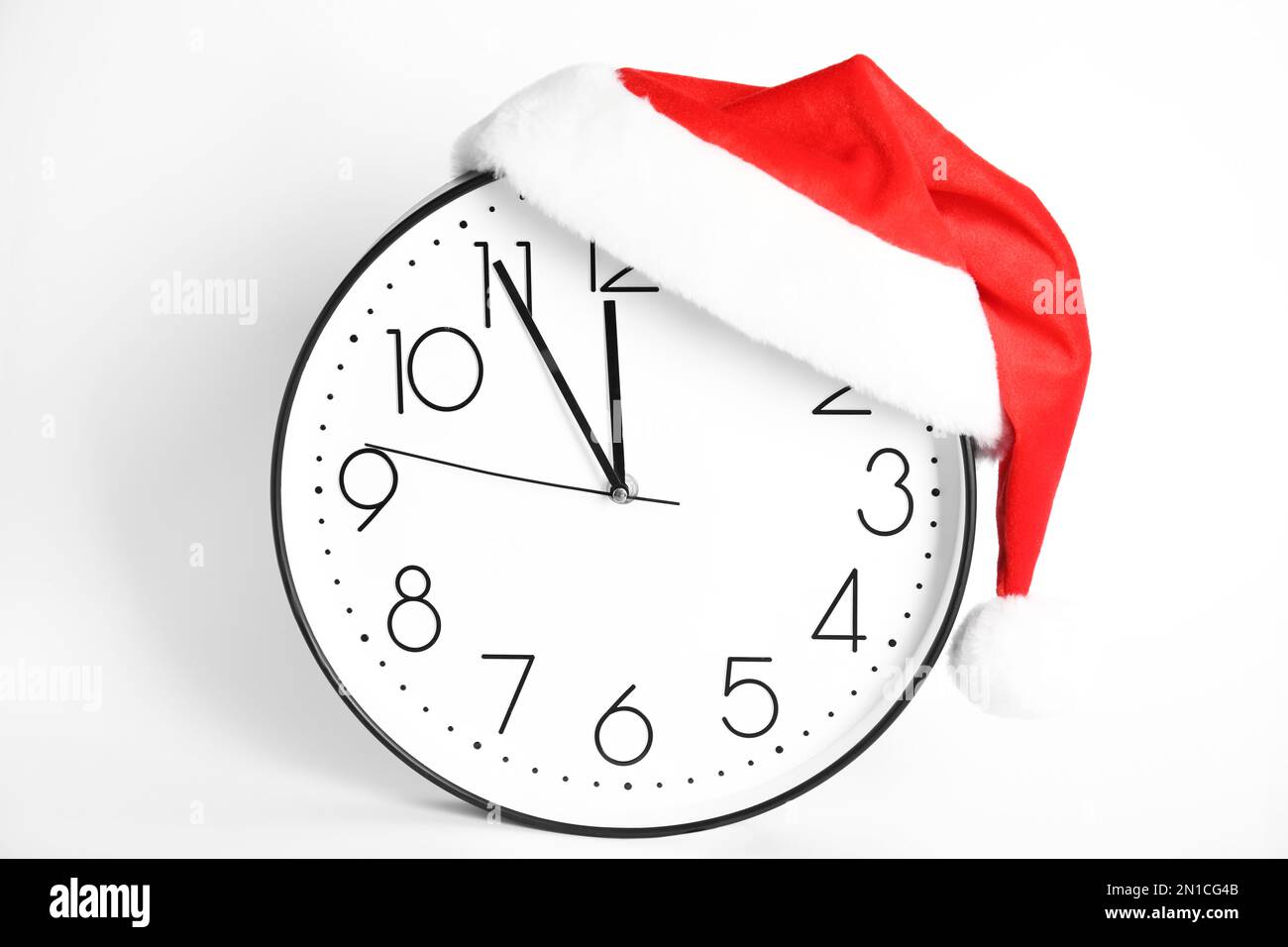 Clock with Santa hat showing five minutes until midnight on white ...