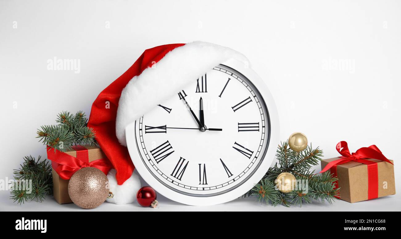 Clock and festive decor on white background. New Year countdown Stock ...