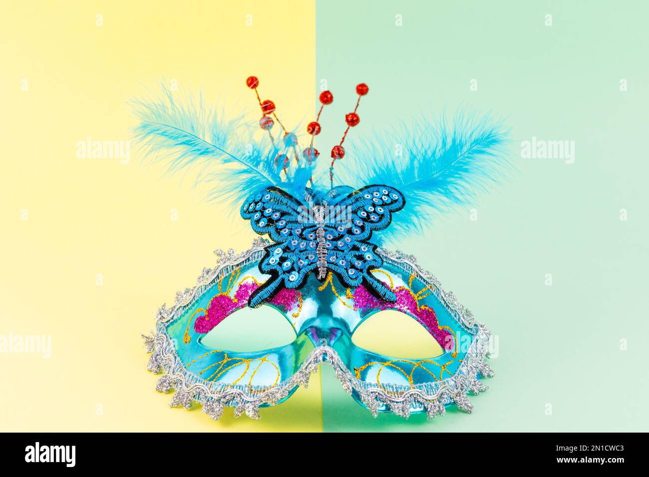 Front view Mardi Gras turquoise mask with yellow and green background ...