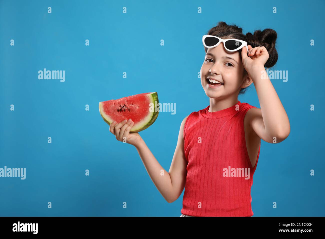 Cute little girl with watermelon on blue background Stock Photo - Alamy